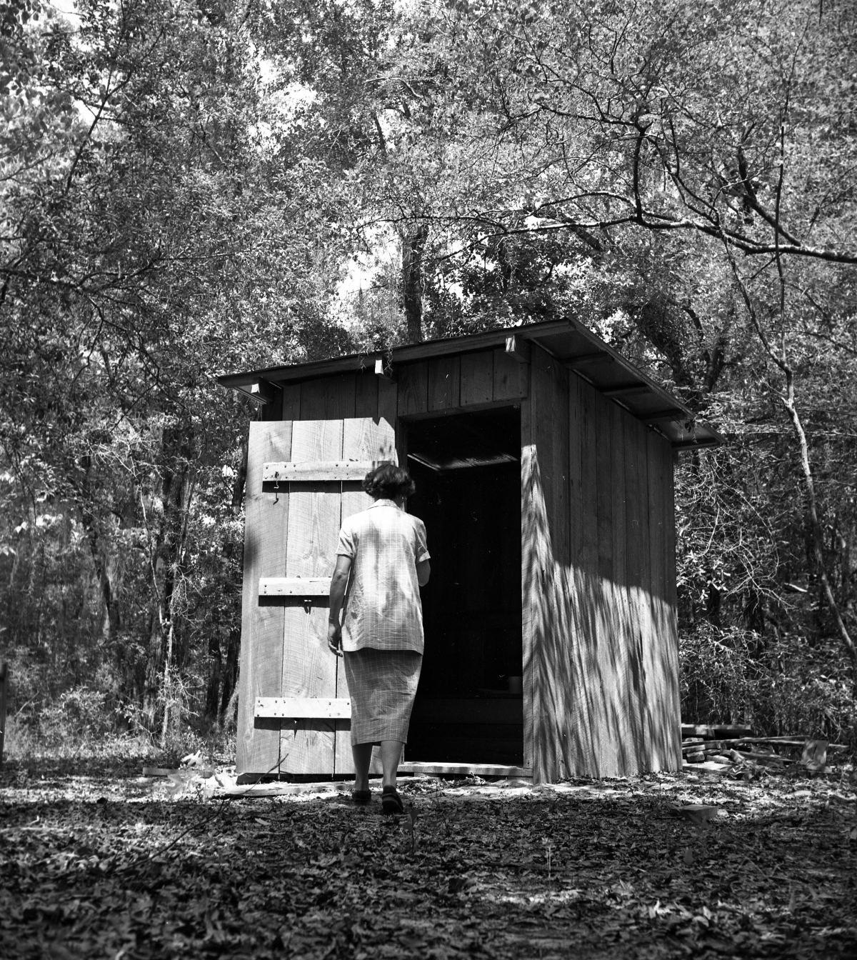 Florida Memory • Woman going into the outhouse in the "Garden of Eden"