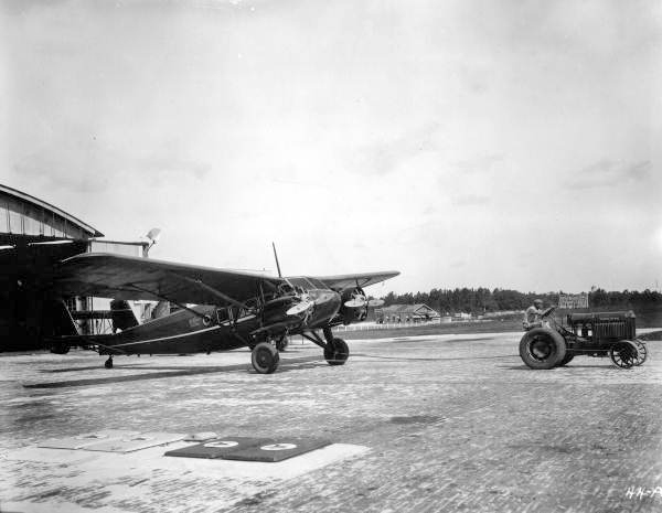 Florida Memory • Tractor pulling a light plane at an airport.